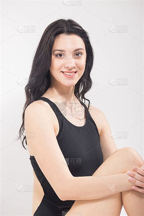 一名年轻女子上身拍照泳装坐着