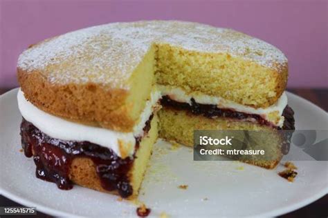 얇게 썬 빅토리아 스폰지 케이크의 이미지 화이트 플레이트에 잼과 버터 크림으로 가득 라일락 핑크 배경에 아이싱 설탕으로 먼지 0명에 대한 스톡 사진 및 기타 이미지 Istock