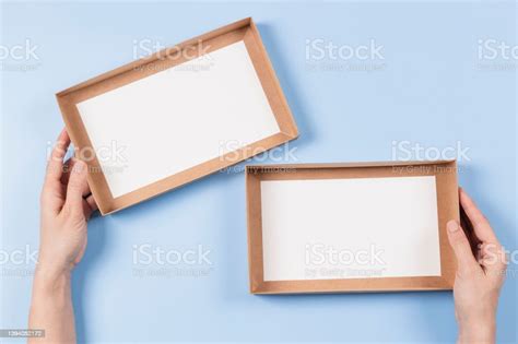 밝은 파란색 배경에 빈 갈색 판지 상자를 들고있는 여성 손의 상단보기 모형 소포 상자 포장 쇼핑 배달 개념 손에 대한 스톡 사진 및 기타 이미지 Istock