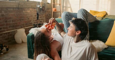 피자 옆 소파에 앉아 있는 남자와 여자 사진 Unsplash의 로프트 이미지