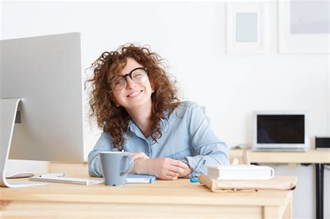 행복 하 게 웃 고 전자 기기 및 컴퓨터 대학 졸업장 프로젝트에 완료 된 작업에 만족 앞 책상에 앉아 행복 한 긍정적인 젊은 성공적인 학생 여성 경영자에 대한 스톡 사진 및