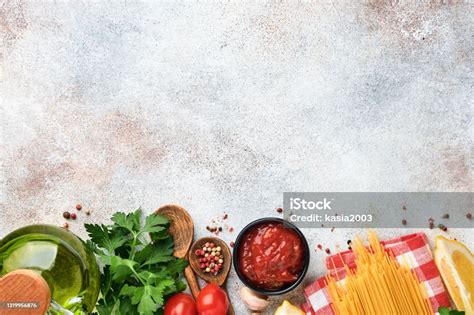 파스타 배경 파스타 스파게티 토마토 케첩 소스 올리브 오일 향신료 파슬리 신선한 토마토가 밝은 회색 슬레이트 테이블에 놓입니다