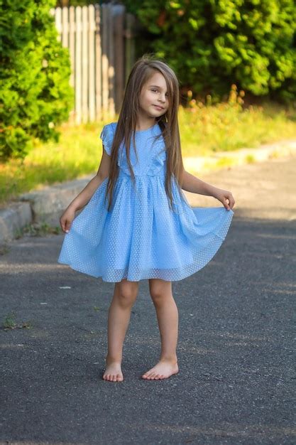 Premium Photo Little Beautiful Girl In A Blue Dress Barefoot In The