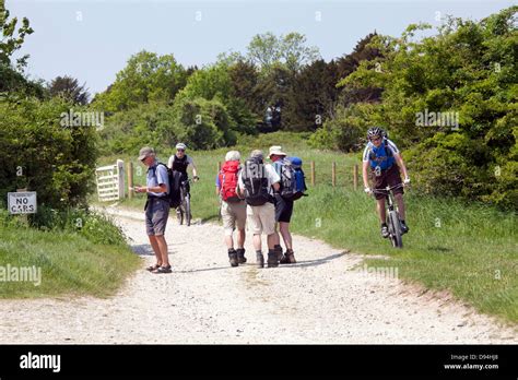 Walkers And Cyclists On The South Downs Way At Bignor Hill West Sussex
