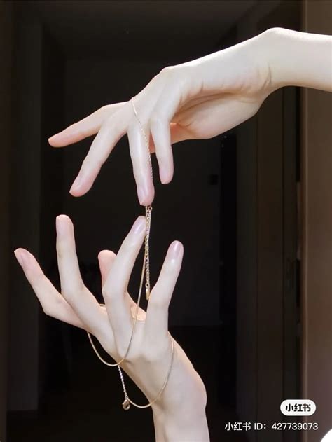 Two Hands Reaching Out To Each Other With Chains On Their Fingers In