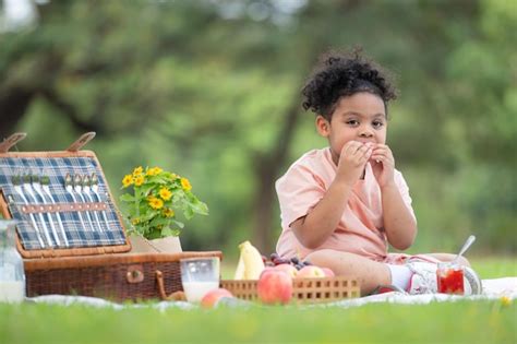 Familia feliz disfrutando de un picnic en el parque con un niño