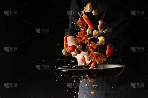 厨师在平底锅中准备大蒜和辣椒腌肉块，在空气中冷冻，在一个黑色的背景上，食谱，菜单，美食，烹饪背景素材 花瓣网