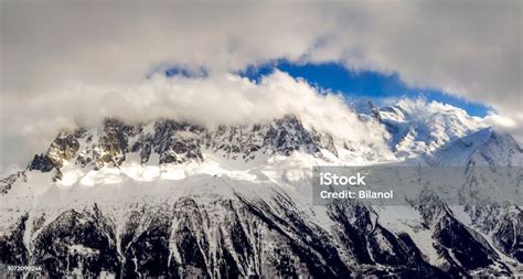 몽블랑 산의 정상의 공중 경치 덮여 빛나는 눈 얼음 및 맑은 분명 감기에 알프스의 프랑스 측에 푹신한 흰 구름과 푸른 하늘 아래 빙하 겨울 날 0명에 대한 스톡 사진 및