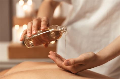 Premium Photo Close Up Of A Woman Masseur Pouring Massage Oil