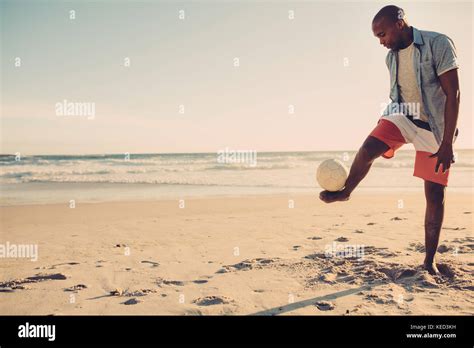Afro American Man Playing With Football Along The Beach Black Male