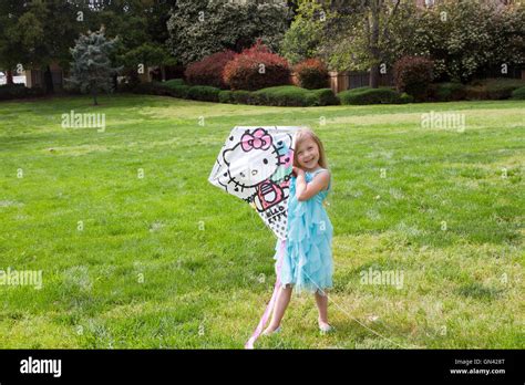 Young Caucasian Girl Laughing As She Runs Trying To Fly Kite Stock