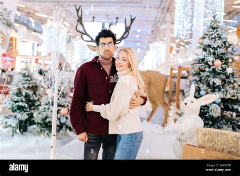 Portrait Of Cheating Wife With Husband With Deer Antlers Hanging Over