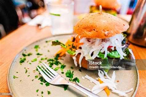 캐주얼한 다이닝 환경에서 장식용 파슬리 장식을 곁들인 접시에 잘게 썬 야채와 잎이 많은 채소를 곁들인 신선하고 맛있는 채식 버거의 클로즈업 건강한 생활방식에 대한 스톡 사진