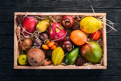 나무 상자에 열 대 과일입니다 파파야 드래곤 과일 람 부탄 타마린드 선인장 과일 아보카도 Granadilla Carambola 금 귤 망고 망고스틴 시계 꽃 열매 코코넛