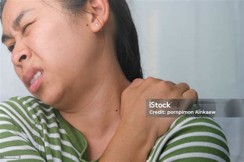 그녀의 목을 잡고 있는 변덕스러운 젊은 여자 피곤한 여자는 뻣뻣한 목을 마사지하고 근육을 긴장시키고 일에서 지쳤다 팔뚝 통증 의료 및 의학 개념입니다 30 34세에 대한