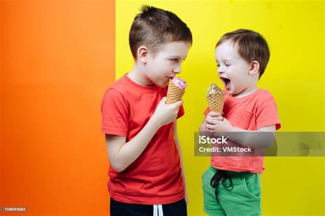 아이스크림 콘을 먹는 웃는 소년은 밝은 색 벽의 배경을 따라 유지 여름 분위기와 웃음 건강한 생활방식에 대한 스톡 사진 및 기타 이미지 건강한 생활방식 건강한 식생활