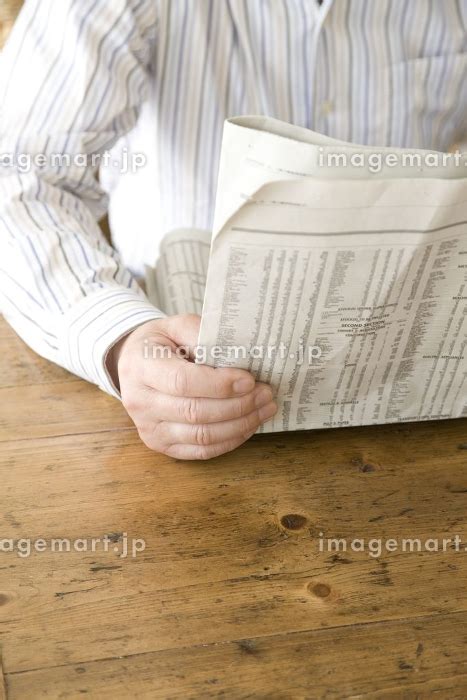 新聞を読むシニア男性の手元の写真素材 24300800 イメージマート