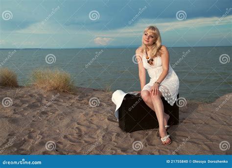 Menina Loura Que Senta Se Em Uma Mala De Viagem Na Praia Foto De Stock