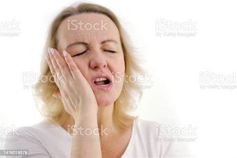 치통 부러짐 치아 물린 뺨 뺨에 상처 입 안쪽 여자 닫힌 눈 뺨에 손을 넣어 불쾌한 감정을 망쳤다 밝은 배경에 금발 중년의 혀
