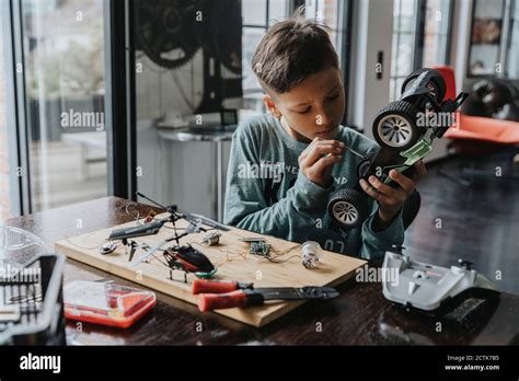 Boy Assembling On Remote Controlled Toy Car With Screwdriver Stock