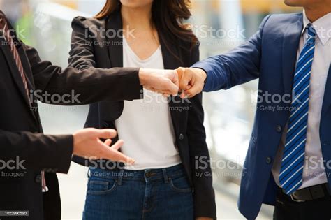 가까이 실업가 주먹을 만들기의 배경에서 젊은 여자와 건물에 밤 비즈니스 사람들이 착용 정장 좋은 거래 후 주먹 펌프에 함께 할