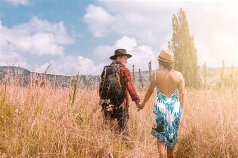 A Lovely Couple Walking Hand In Hand Through A Dry Summer Field Stock