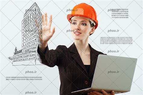 عکس با کیفیت مهندس ساختمان با کلاه ایمنی نارنجی و لپ تاپ به دست در حال تاچ کردن صفحه مانیتور