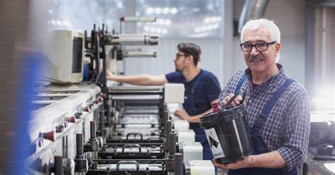 산업용 인쇄 기계에 잉크를 붓는 콧수염을 가진 웃는 노인의 초상화 사진 Unsplash의 공장 이미지