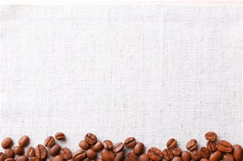 Cornice di chicchi di caffè su sfondo di tela di sacco a colori Foto