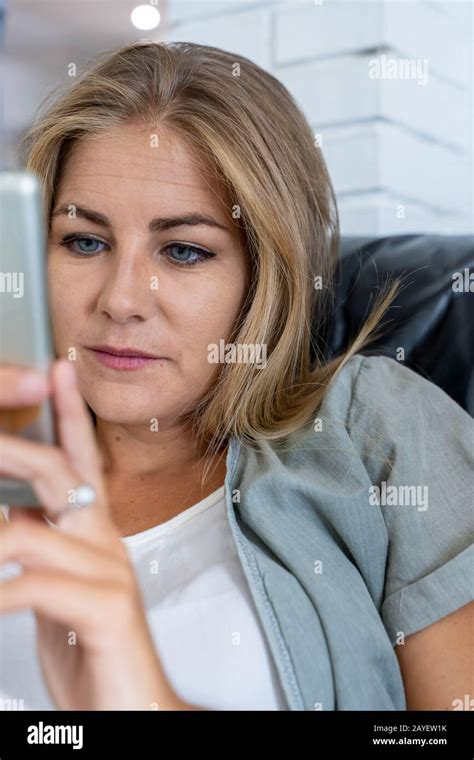 Stock Vertical Photo Of A Blonde Girl With Makeup Sitting On A Black