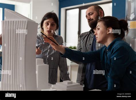 Professional Team Of Architects Analyzing Maquette Building Model Group Of Engineer Partners
