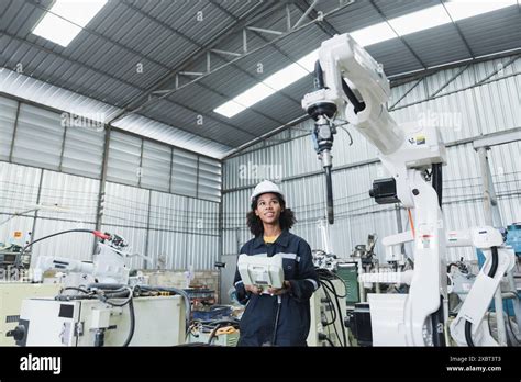 Engineer Controlling Robot Arm At Factory Checking The Operation Of Robot Arm Technology