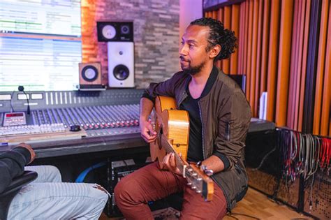 음악 믹서 옆의 녹음 스튜디오에서 어쿠스틱 기타를 연주하는 흑인 남성 기타리스트 기타 연주자에 대한 스톡 사진 및 기타 이미지 기타 연주자 기타 현악기 스피커