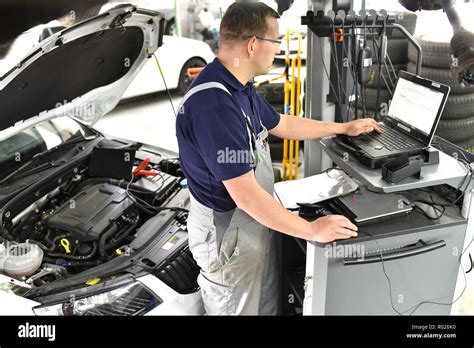 car mechanic maintains a vehicle with the help of a diagnostic computer - modern technology in ...