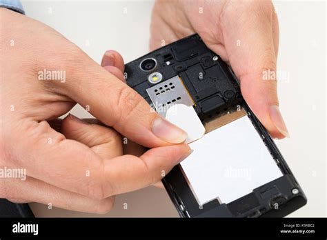 Close Up Of Person Hand Inserting A Sim Card Into Mobile Phone Stock Photo Alamy