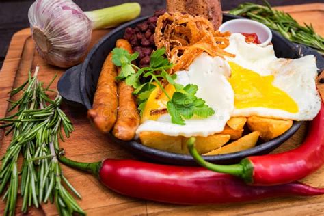 Еда с яичницей сосисками фасолями кольцами лука перцем Chili и
