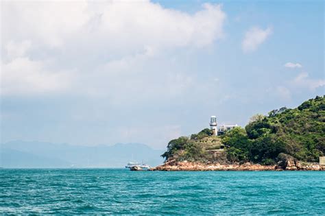 바다 위에 섬 절벽에 작은 흰색 등 대 남 옥 물 푸른 하늘 아름 다운 바다 경치입니다 여객 항해 선박 섬 뒤에 이동입니다 0