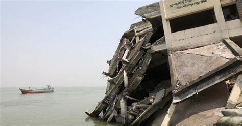 A Boat Is In The Water Next To A Building That Has Been Torn Down And