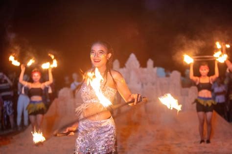 Un Grupo De Personas En Una Actuación En La Playa Con Antorchas De