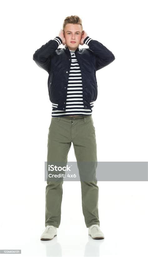 シャツを着て白い背景の前に立っている白人の若い男性 ティーンエイジャーのストックフォトや画像を多数ご用意 ティーンエイジャー 耳を