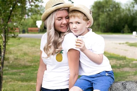 Premium Photo Portrait Of Mother And Son Sitting At Park