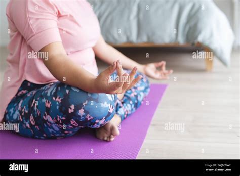 Young Plus Size Biracial Woman Practices Yoga At Home With Copy Space