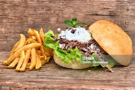 Tzatziki 소스 Bbq 소스 및 나무 배경 튀김 그린 샐러드와 바베 큐 뽑아 돼지고기 샌드위치 갈기갈기 찢어진에 대한 스톡
