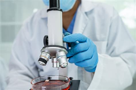 실험실에서 현미경으로 연구하는 아시아 과학자 생화학자 또는 미생물학자 프리미엄 사진