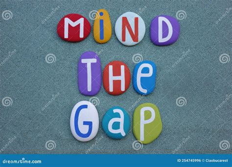 Mind The Gap Creative Logo Composed With Multi Colored Stone Letters Ovver Green Sand Stock