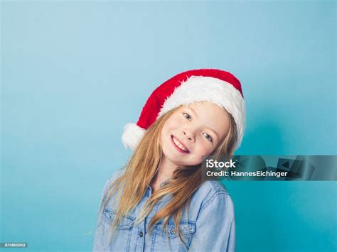 크리스마스 모자 스튜디오에서 파란색 배경 앞에서 젊은 아름 다운 금발 소녀 금발 머리에 대한 스톡 사진 및 기타 이미지 금발 머리 소녀 크리스마스 Istock