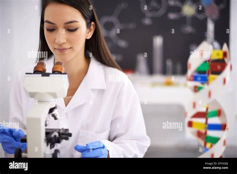 Unlocking The Secrets Of Genetics Profile Of A Female Scientist Viewing A Sample Through A