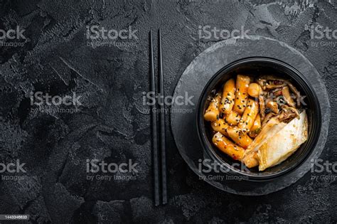 한국 길거리 음식 떡볶이 토볶이 떡 매운 소스에 붙어 있습니다 검은 배경입니다 평면도 복사 공간 떡볶이에 대한 스톡 사진 및