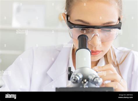Beautiful Female Scientists Are Looking At The Microscopes In A Science