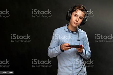 헤드폰을 신고 스마트폰으로 게임을 하는 십대 소년 검은 배경 공간을 복사합니다 엔터테인먼트 및 현대 기술의 개념 십대 소년에 대한 스톡 사진 및 기타 이미지 Istock
